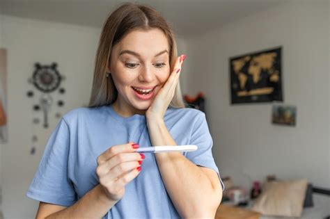 Premium Photo Delighted And Surprised Woman Holding Pregnancy Test