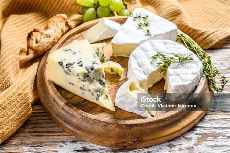 둥근 나무 도마에 다양한 치즈 카망베르 브리 블루 치즈와 포도 흰색 나무 배경 위쪽 보기 곰팡이에 대한 스톡 사진 및 기타 이미지 Istock