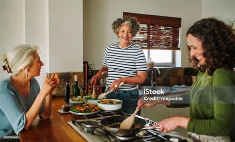 휴가용 임대 주택의 부엌에서 함께 요리하면서 웃고 있는 중년 여성들 요리하기 음식 준비에 대한 스톡 사진 및 기타 이미지 요리하기 음식 준비 노인 건강한 식생활