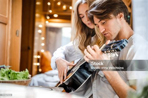 젊은 그냥 결혼 한 커플 캠핑카에서 여행하는 연인 바퀴에 집 트레일러 모터 홈 낭만적 인 도로 여행 자유 생활을 사랑하십시오 작은 부엌 밴에서 요리 기타를 연주하고 노래를