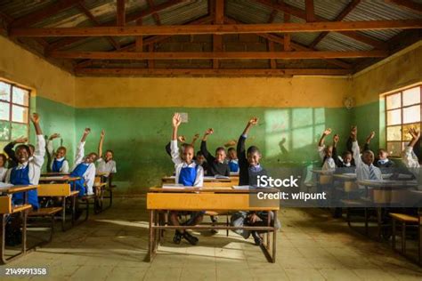 시골 아프리카 학교 교실은 교복을 입은 행복한 십대들이 손을 들고 있습니다 12 13세에 대한 스톡 사진 및 기타 이미지 12 13세 14 15 살 16 17 살