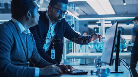 Two Developers Working On Computer With Green Screen Mock Up Display