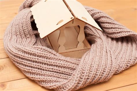 House Model Wearing Knitted Scarf And Autumn Leaf On Wooden Blue Table Heating System Cold