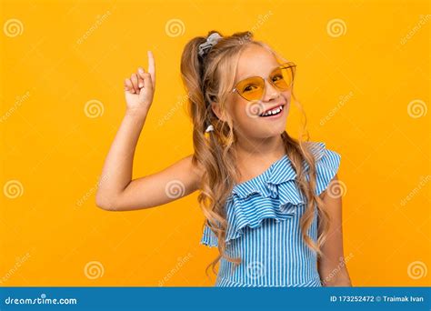 Glad Tjej I Klänningsleenden Har En Idé Isolerad På Gul Och Orange