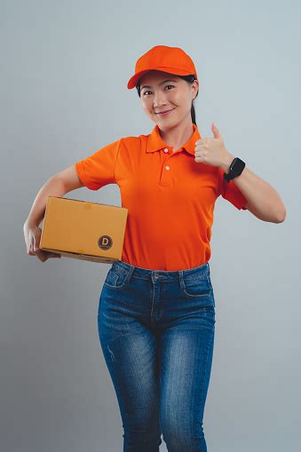 유니폼 폴로 티셔츠를 입고 상자를 들고 행복한 미소를 짓고 있는 아시아 여성은 하얀 배경 위에 고립되어 서 있다 여자에 대한 스톡 사진 및 기타 이미지 Istock