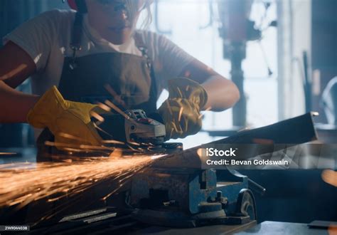 금속 용접 및 생산을 위한 작업장에 있는 불꽃을 가진 분쇄기 그리고 철 절단 잎을 가진 여자 공구 제조 및 수리 전력 및 전기 기계가 있는 산업 공장에서 작업 35 39세에