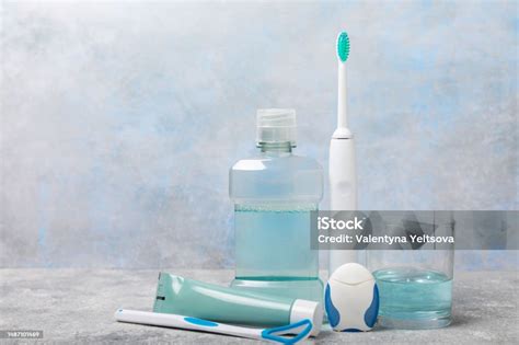 파란 벽에 음파 전동 칫솔 치약 구강 세정제 치실 혀 클리너가 있는 욕실 구강 위생 치과 치료 치과 개념입니다 텍스트를 위한 위치입니다 복사 장소 모형 0명에 대한 스톡