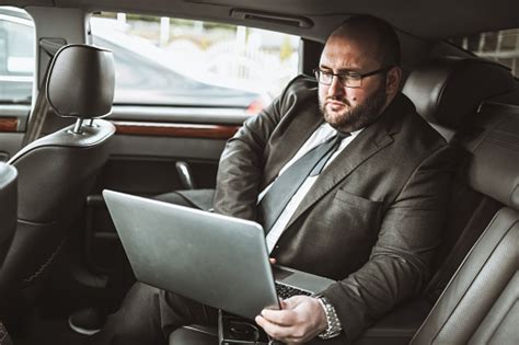 자동차로 여행하는 동안 노트북에서 일하는 중년 사업가 Brand Name Smart Phone에 대한 스톡 사진 및 기타 이미지