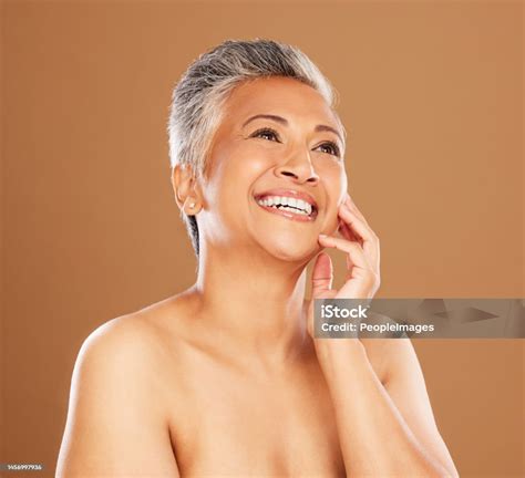 얼굴 아름다움 노화 방지는 갈색 배경에 스튜디오에서 스킨케어에 대해 생각하는 노인 여성과 함께 있습니다 아이디어 고급 스러움 및 웰빙 자연스러운 피부 치료를 촉진하기 위해