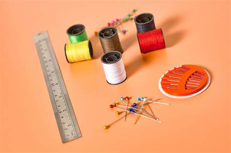 흩어진 바늘 금속 통치자 및 작업장에서 오렌지 재단사 책상에 다채로운 스레드가있는 스풀 클로즈업 개념에 대한 스톡 사진 및 기타 이미지 Istock