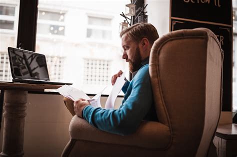 젊은 빨강 머리 사업가 문서를 탐색 하는 커피 브레이크에 그는 카페에 앉아 경영자에 대한 스톡 사진 및 기타 이미지 경영자