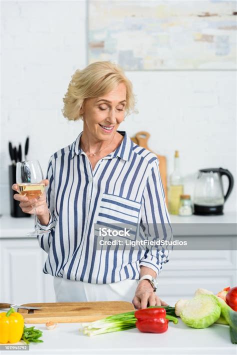 매력적인 수석 여 자가 부엌에 야채 보고 화이트 와인의 유리를 들고 웃 고 건강한 생활방식에 대한 스톡 사진 및 기타 이미지 건강한 생활방식 건강한 식생활 날것