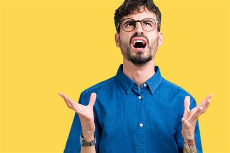 젊은 잘생긴 남자에 안경을 쓰고 배경 미친 격리 하 고 미친 소리 하 고 적극적인 식와 팔 발생 함 좌절 개념입니다 T 셔츠에