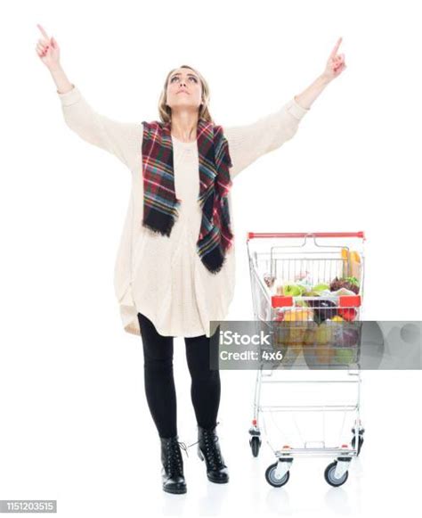 쇼핑 카트 옆에 서 있는 아름 다운 젊은 백인 여자전면 보기 포인팅 및 터치 20 29세에 대한 스톡 사진 및 기타 이미지 20 29세 25 29세 가리키기 Istock