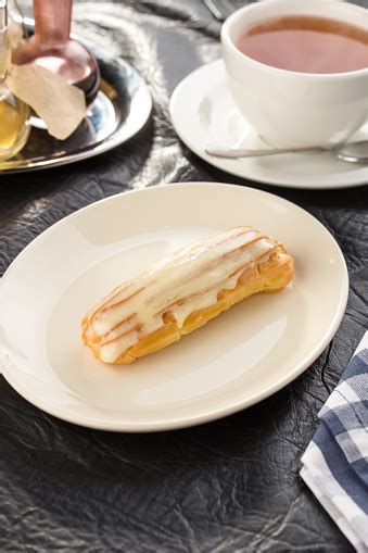 화이트 플레이트에 바닐라 소스를 얹은 홈메이드 에클레어 디저트와 차 한 잔 갈색에 대한 스톡 사진 및 기타 이미지 갈색 달콤한 음식 러시아 Istock