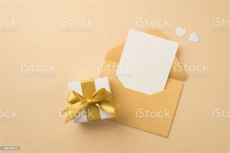 빈 공간이있는 고립 된 베이지 색 배경에 금 리본 리본 이있는 오픈 파스텔 노란색 봉투와 흰색 선물 상자의 상단 보기 사진 리본에 대한 스톡 사진 및 기타 이미지 Istock