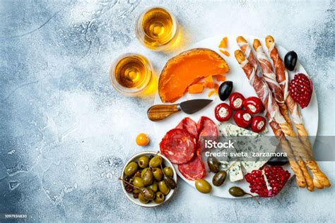 안경에 전채 요리와 와인과 함께 애피타이저 테이블 정통 스페인 전통 타파스 세트 치즈와 회색 콘크리트 배경 위에 고기 플래터