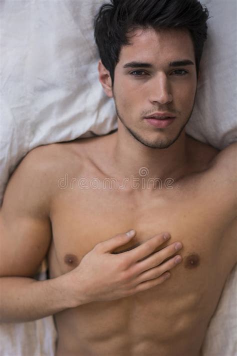 Modelo Masculino Atractivo Descamisado Que Miente Solamente En Su Cama