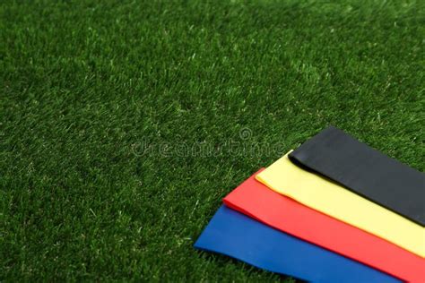 Fitness Elastic Bands On Green Grass Space For Text Stock Image