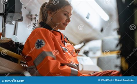 Tired Female Ems Professional Paramedic Tries To Rest In An Ambulance