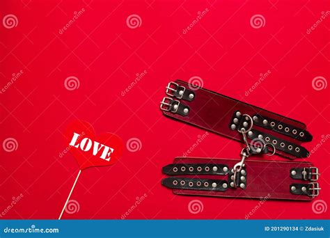 Red Color Banner With Black Leather Bracers And Metal Rivets For Shackling Hands Or Legs And