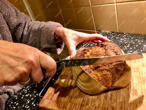 Premium Photo Midsection Of Woman Cutting Bread On Table At Home