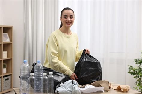 Premium Photo Smiling Woman With Plastic Bag Separating Garbage In Room