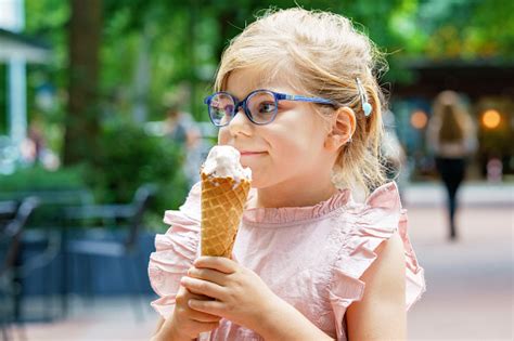 화창한 여름날에 와플 콘에서 아이스크림을 먹는 안경을 쓴 어린 미취학 소녀 행복한 유아 아이는 아이스크림 디저트를 먹는다 더운 따뜻한 여름철에 달콤한 음식 공원에 대한 스톡