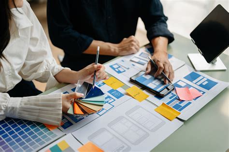 Ux 개발자와 Ui 디자이너가 사무실에서 고객 브리프와 색상 코드를 사용하여 모바일 앱 인터페이스 와이어프레임 디자인에 대해