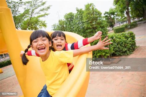 화창한 여름 날에 야외 에서 재미를 귀여운 어린 소녀 형제 플라스틱 슬라이드에 어린이 아이들을위한 재미있는 활동 아이들을위한 활동적인 스포츠 레저 놀이에 대한 스톡 사진 및