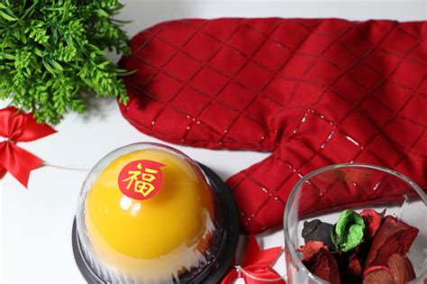 중국어 언어 블 리스 레드 주방 장갑 빨간 리본 및 말린된 꽃에서 오렌지 케이크에 막대기와 흰색 바닥에 녹색 잎 개념에 대한