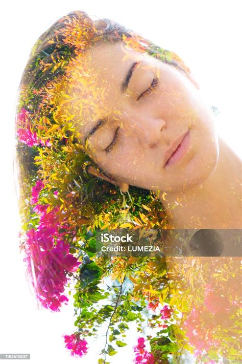 머리를 옆으로 기울이고 긴 갈색 머리를 가진 젊고 편안한 자연의 아름다움의 이중 노출 초상화는 흰색 배경에 밝은 분홍색 꽃과 결합 Mental Wellbeing에 대한 스톡