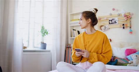 슬픈 젊은 여학생이 침대에 앉아 스마트폰을 사용하고 있다 공간을 복사합니다 사진 Unsplash의 슬로바키아 이미지