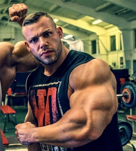 A Man Flexing His Muscles In The Gym