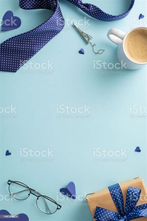 텍스트나 광고를 위한 빈 공간이 있는 파스텔 블루 배경에 상단 보기 세로 사진 커피 넥타이 클립 안경 선물 상자 및 남성