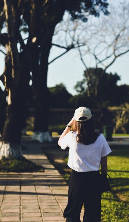 햇살 가득한 공원을 산책하는 젊은 여성 · 무료 스톡 사진
