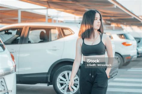 주차장에서 걷고 있는 검은 탑에 어깨 길이의 머리를 가진 아름다운 백인 소녀 검은색에 대한 스톡 사진 및 기타 이미지 검은색 관능 나이 Istock
