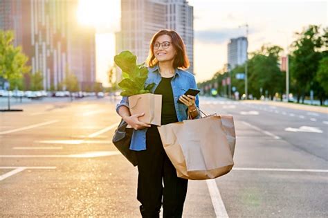 쇼핑몰 주차장에서 쇼핑백을 들고 있는 중년 여성의 도시 초상화 40 49세에 대한 스톡 사진 및 기타 이미지 40 49세