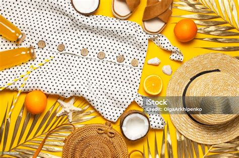 여름 배경 해변 액세서리 비치 위커 밀짚 등나무 여성 에코 백 화이트 드레스 모자 샌들 황금 열대 잎 코코넛 오렌지 주스 조개 불가사리 노란색 배경에 불가사리 플랫 레이