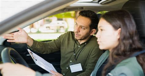 30대 잘생긴 남자와 운전면허 시험을 위해 차 안에 앉아 있는 아름다운 십대 소녀 수업 중 사춘기 소녀에게 지시를 내리는 남성 강사 사진 Unsplash의 선생 이미지