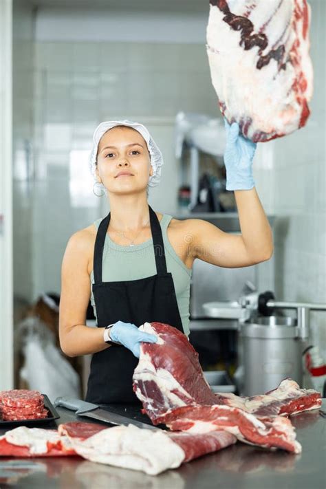 Girl In Butcher Shop Cuts Meat Carcass Into Small Pieces Of Meat For
