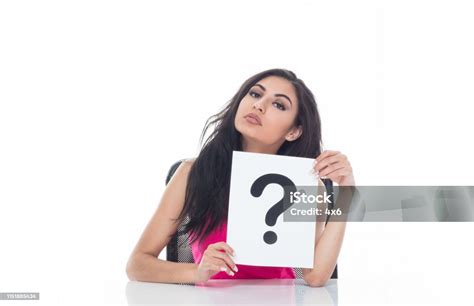 물음표 기호를 들고 흰색 책상에 앉아 아름 다운 라틴 여자 18 19세에 대한 스톡 사진 및 기타 이미지 18 19세 검정 머리 긴 머리 Istock