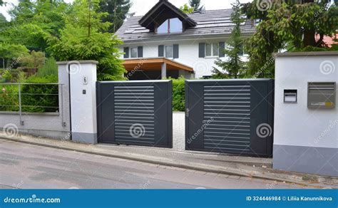 A Modern Two Door Aluminum Gate With Silver Stripes An Intercom