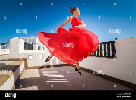 Attractive Flamenco Dancer Wearing Traditional Red Dress With Flower In
