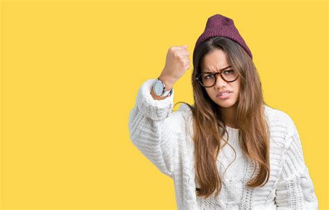 이상의 안경 및 겨울 모자를 입고 젊은 아름 다운 갈색 머리 Hipster 여자 절연 배경 화와 좌절과 분노와 함께 외치는 동안