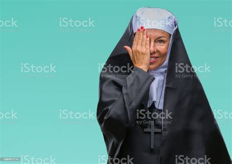 격리 된 배경 얼굴과 놀라운 감정에 확신 미소와 함께 손으로 한쪽 눈을 덮고 위에 중 년 수석 기독교 가톨릭 수녀 여자 가리기에 대한 스톡 사진 및 기타 이미지 Istock
