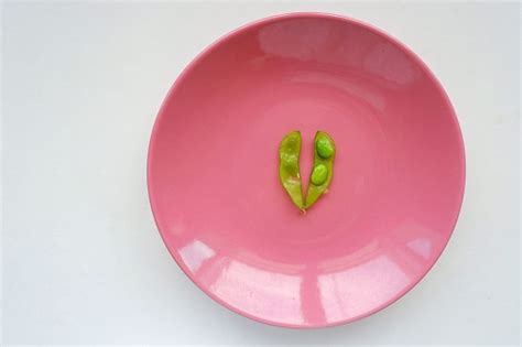 부엌 방에서 빈티지 화이트 테이블 배경에 고립 된 원형 파스텔 핑크 컬러 플레이트에 분할 녹색 Edamame 콩 일본의 탑 아이 뷰 조각 0명에 대한 스톡 사진 및 기타