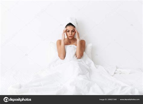 Sad Amazing Woman With Towel On Head Lies In Bed Under Blanket Isolated