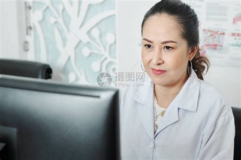 亚裔成年女在办公室工作场所工作时看计算机监视器的亚洲高清图片下载 正版图片504474462 摄图网