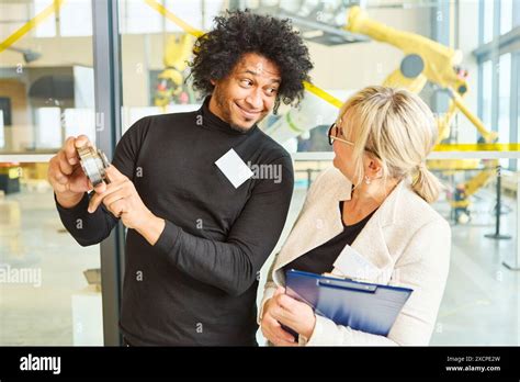 Two Engineers Engaging In A Lively Discussion About Robotic Automation